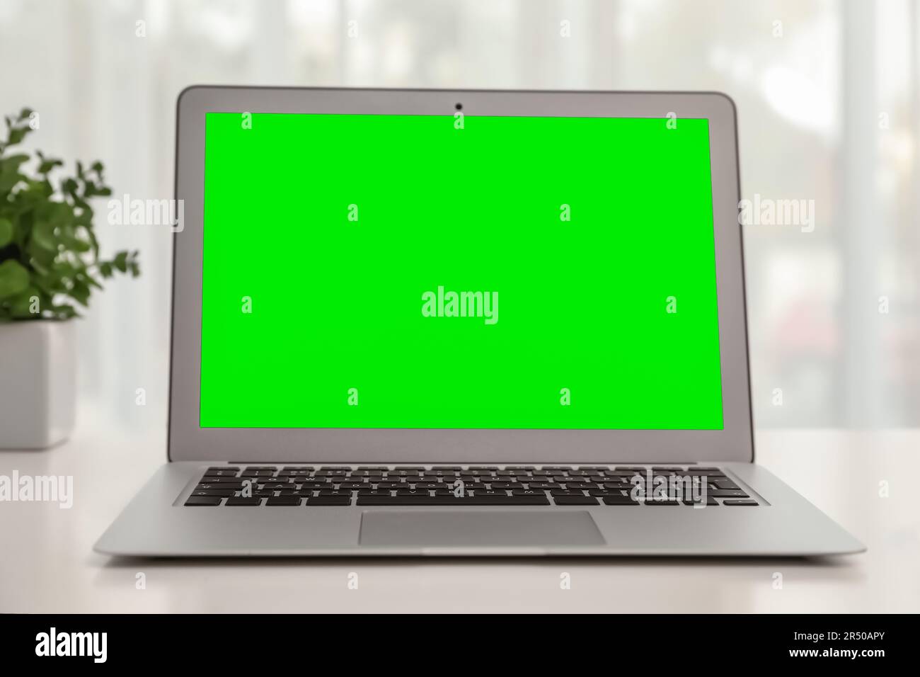 Laptop display with chroma key on desk in room. Comfortable workplace ...