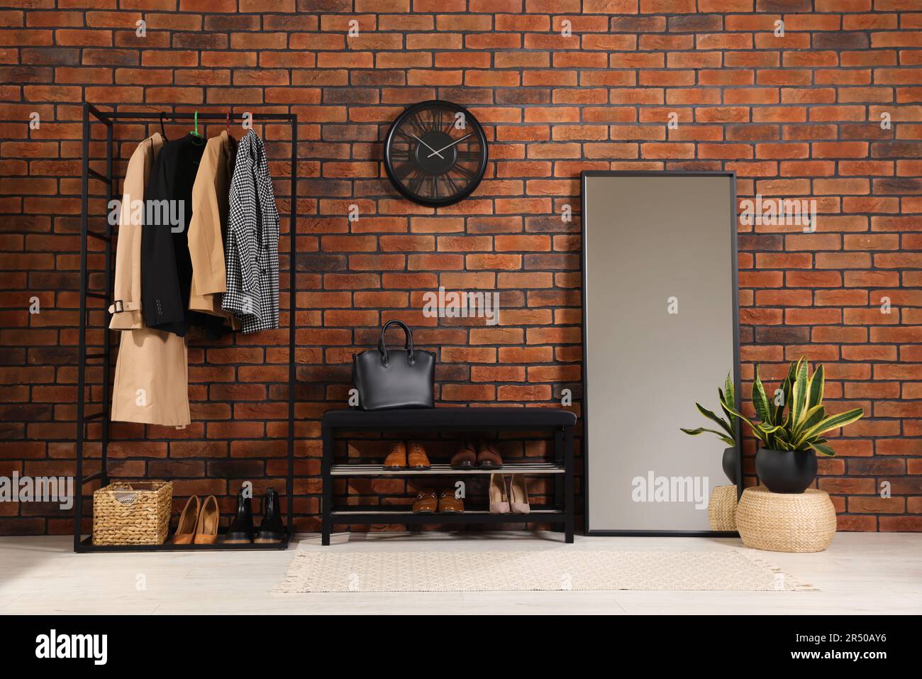 Stylish hallway with coat rack, mirror and shoe storage bench near ...