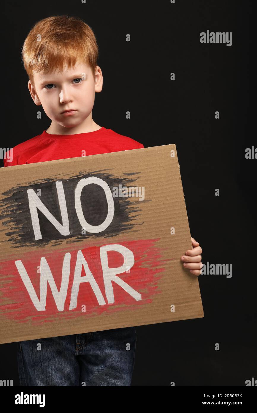 Boy holding poster No War against black background Stock Photo - Alamy