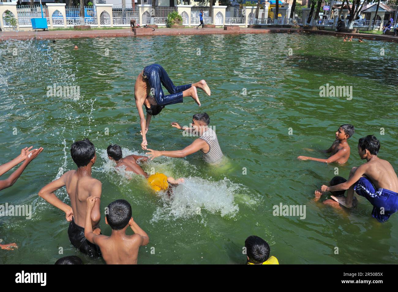 Sylhet, Bangladesh. 30th May 2023. Local children playing in a pond during a summer heat wave in ...