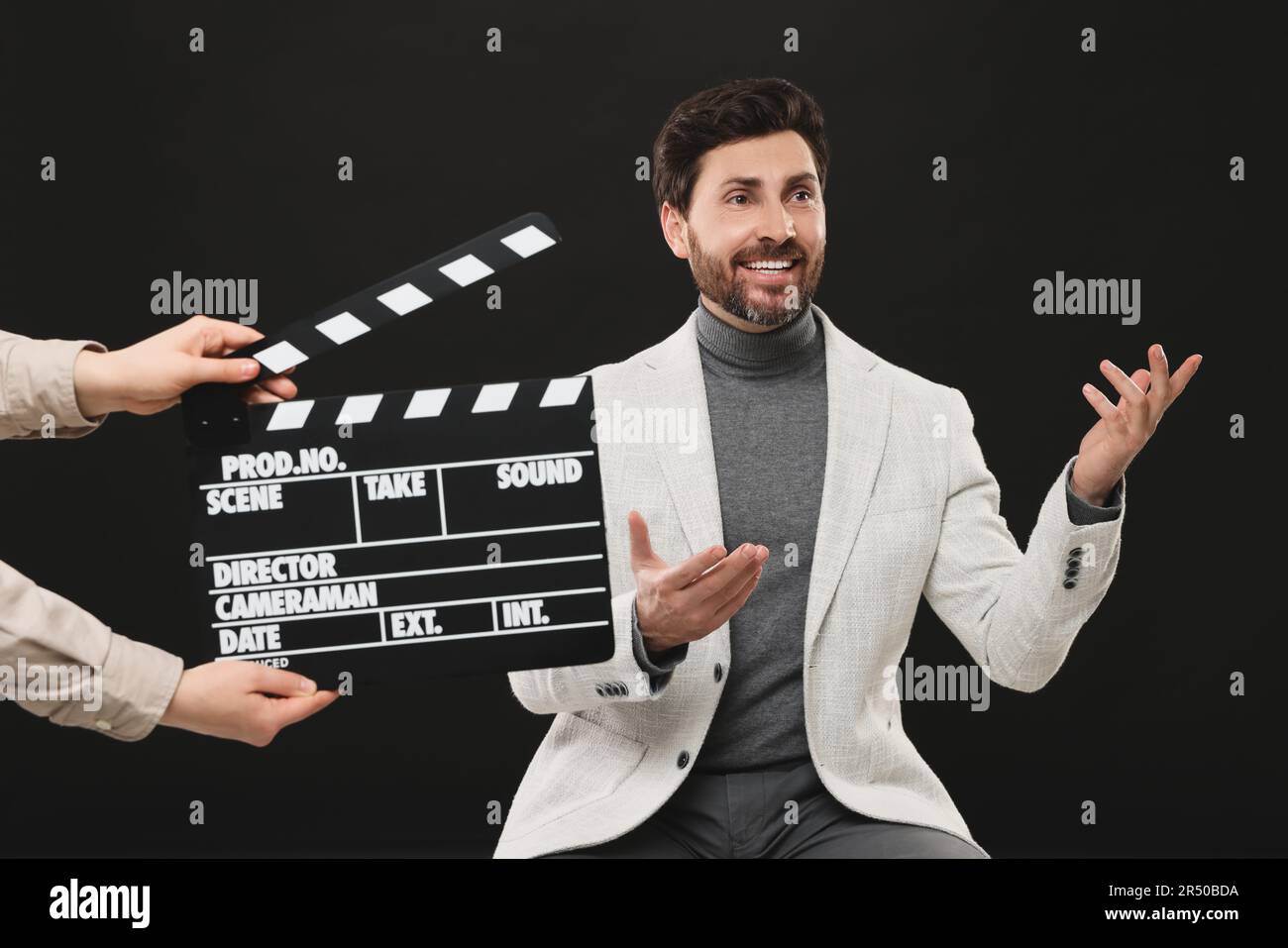Actor performing while second assistant camera holding clapperboard on ...