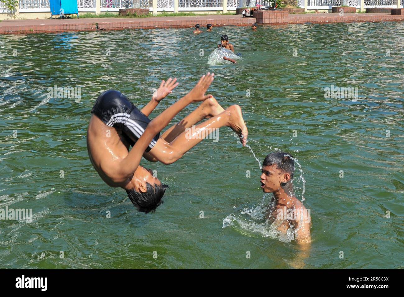 Sylhet, Bangladesh. 30th May 2023. Local children playing in a pond during a summer heat wave in ...