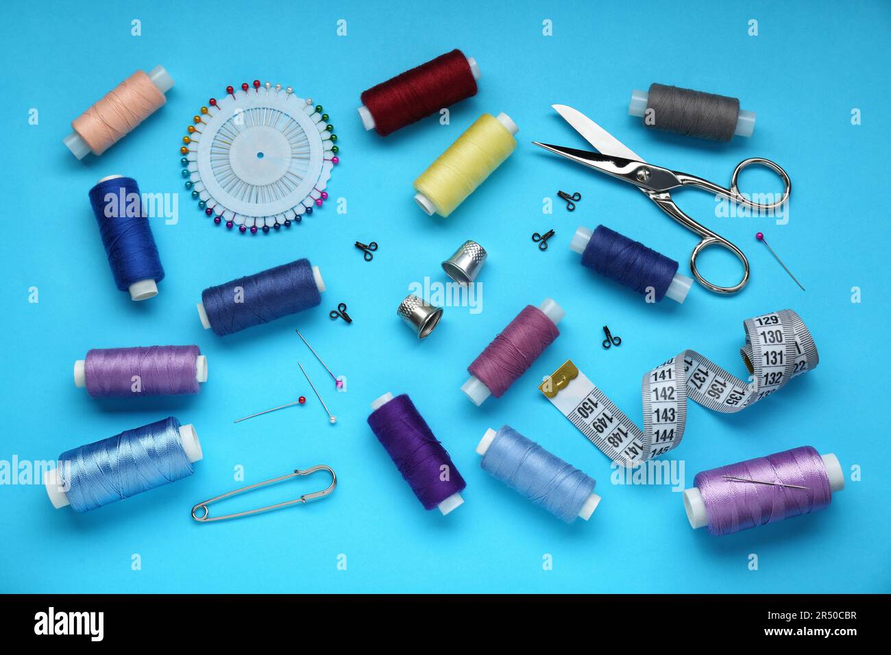 Flat lay composition with thimbles and different sewing tools on light ...