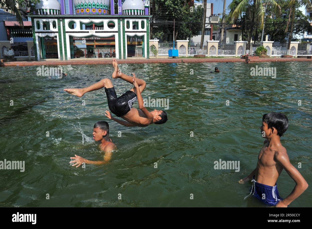 Sylhet, Bangladesh. 30th May 2023. Local children playing in a pond during a summer heat wave in ...