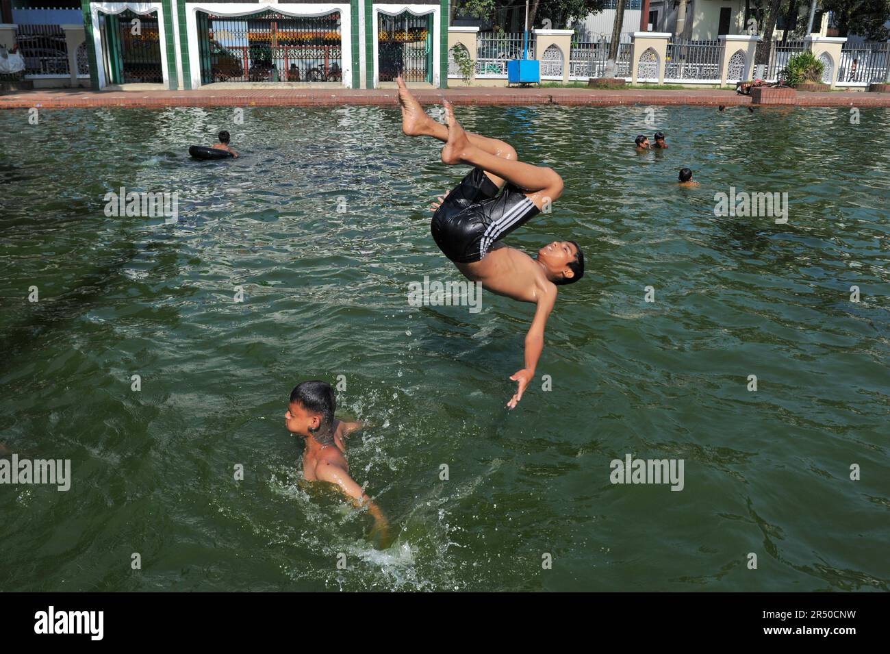 Sylhet, Bangladesh. 30th May 2023. Local children playing in a pond during a summer heat wave in ...