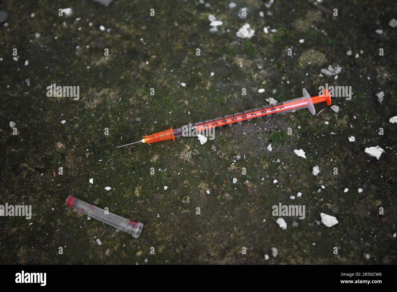 Empty disposable syringe with needle on street Stock Photo - Alamy