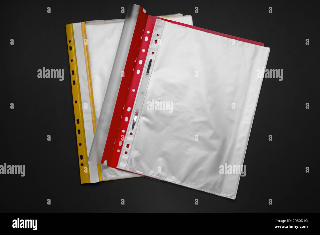 File folders with punched pockets and paper sheets on black background ...