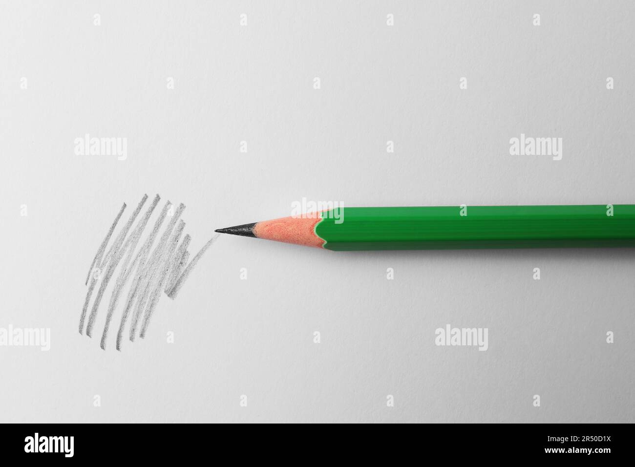 Sharp graphite pencil and hand drawn scribble on white sheet of paper ...