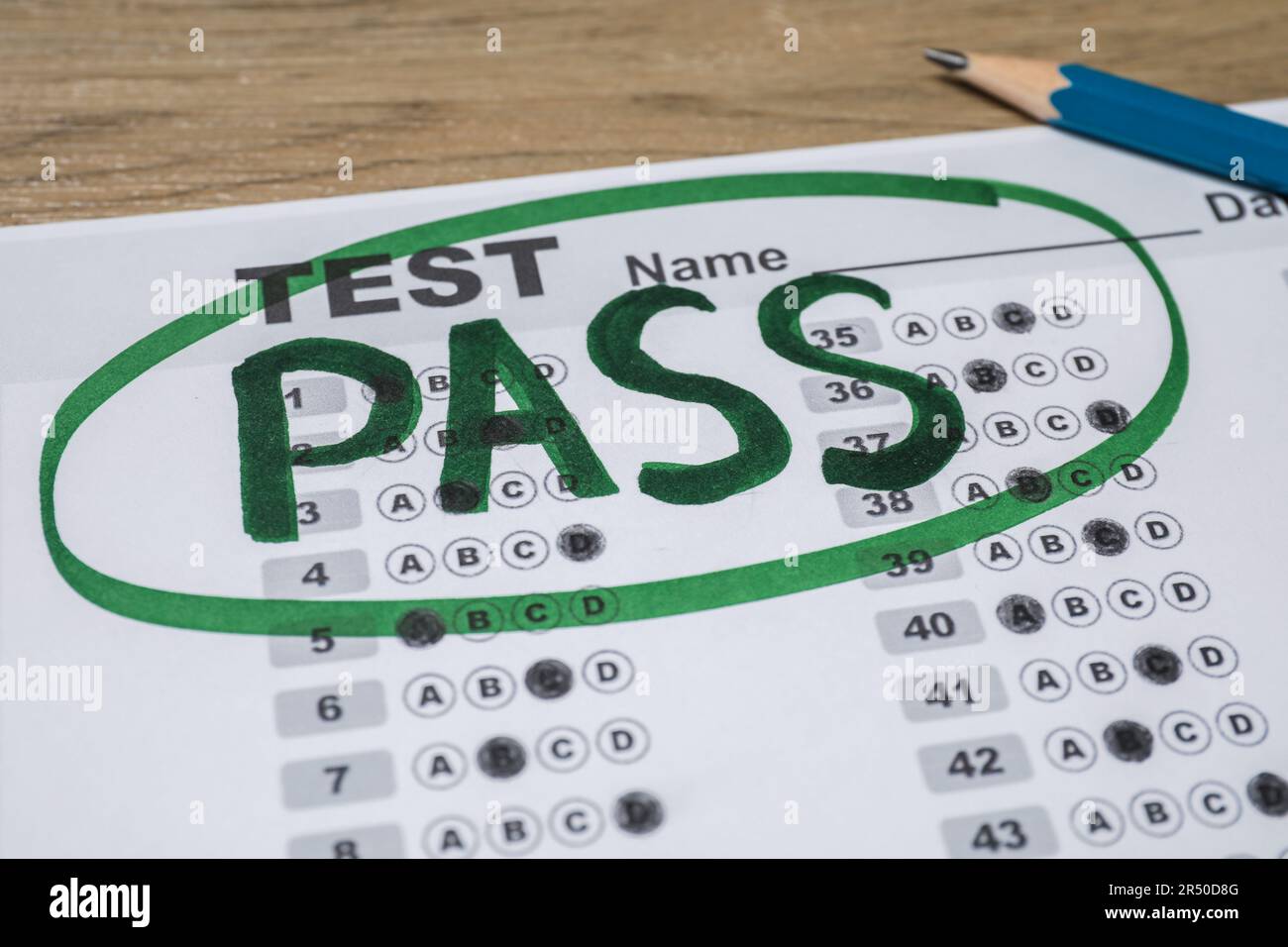 Answer sheet with word Pass and pencil on wooden table, closeup ...