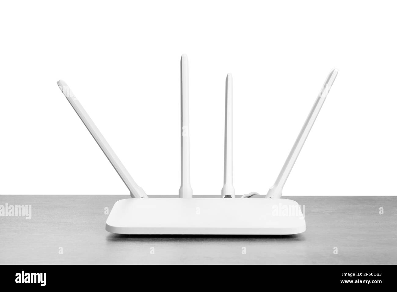 New modern Wi-Fi router on grey table against white background Stock ...