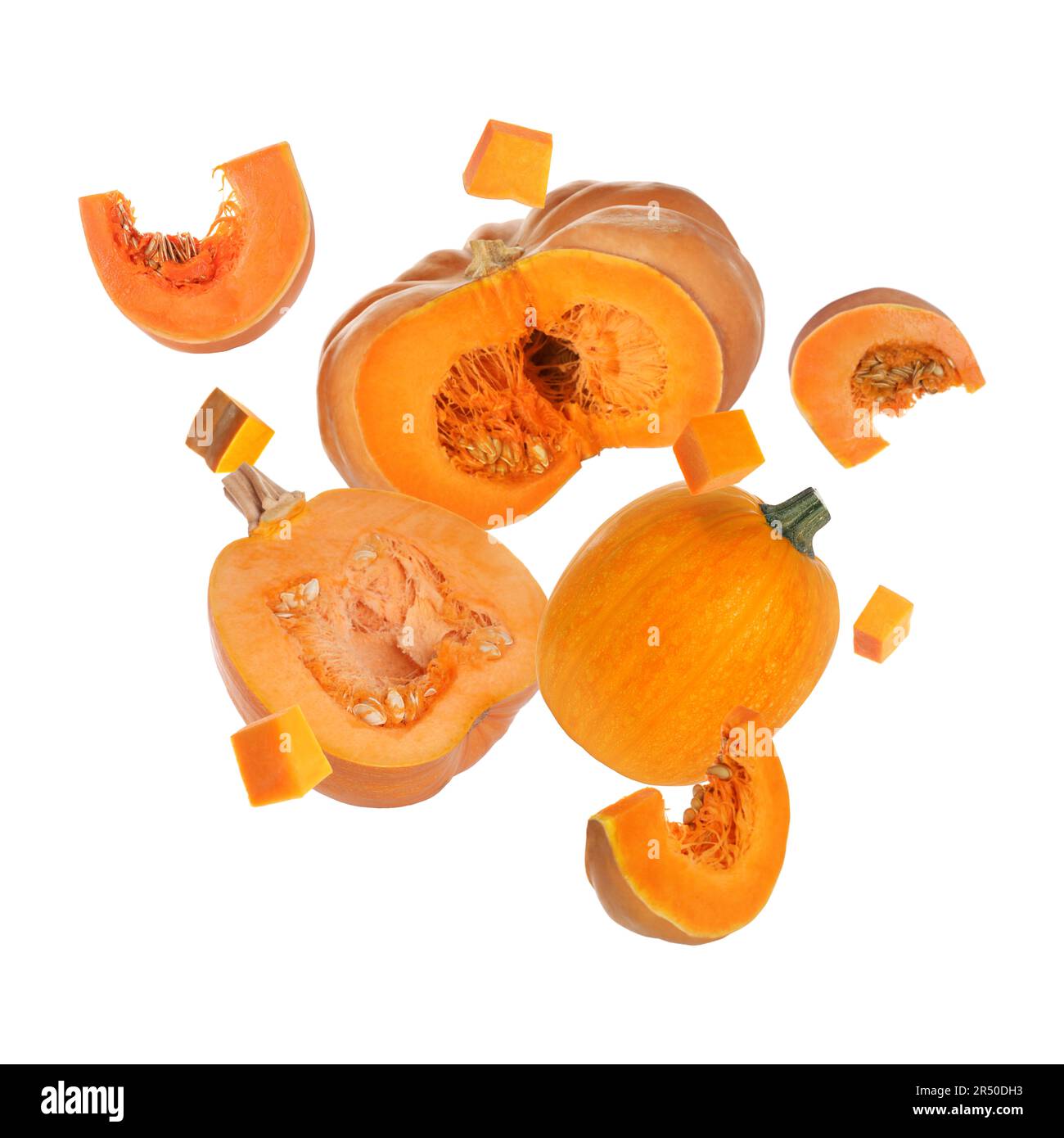 Whole and cut pumpkins falling on white background Stock Photo - Alamy