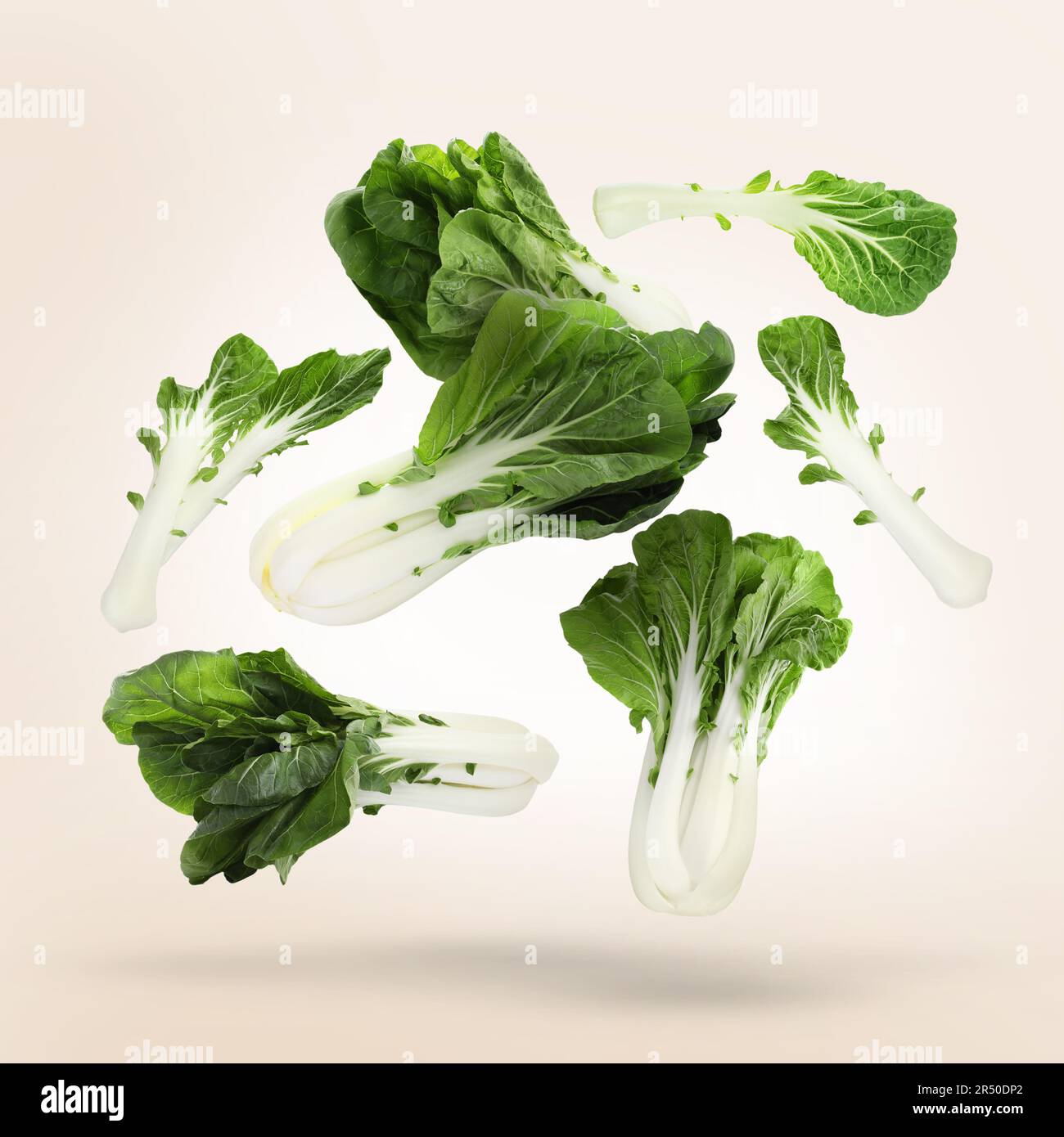 Fresh green pak choy cabbages falling on light background Stock Photo ...