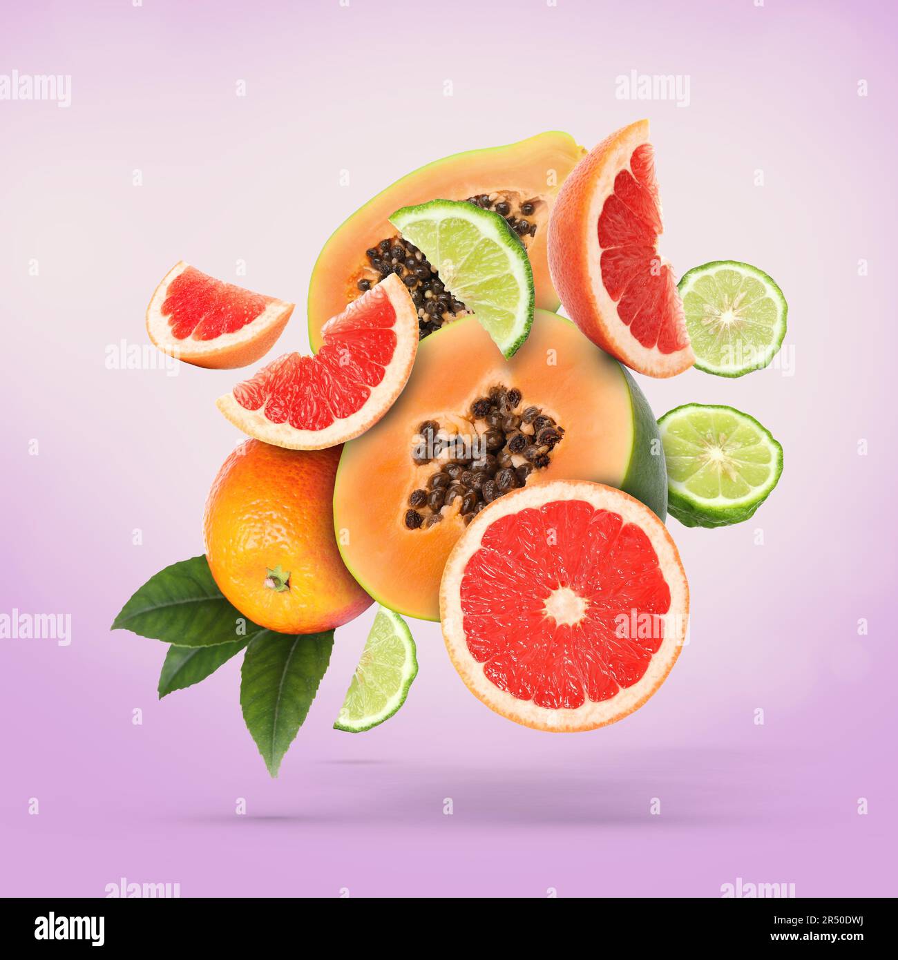 Many fresh tropical fruits falling on light violet background Stock ...