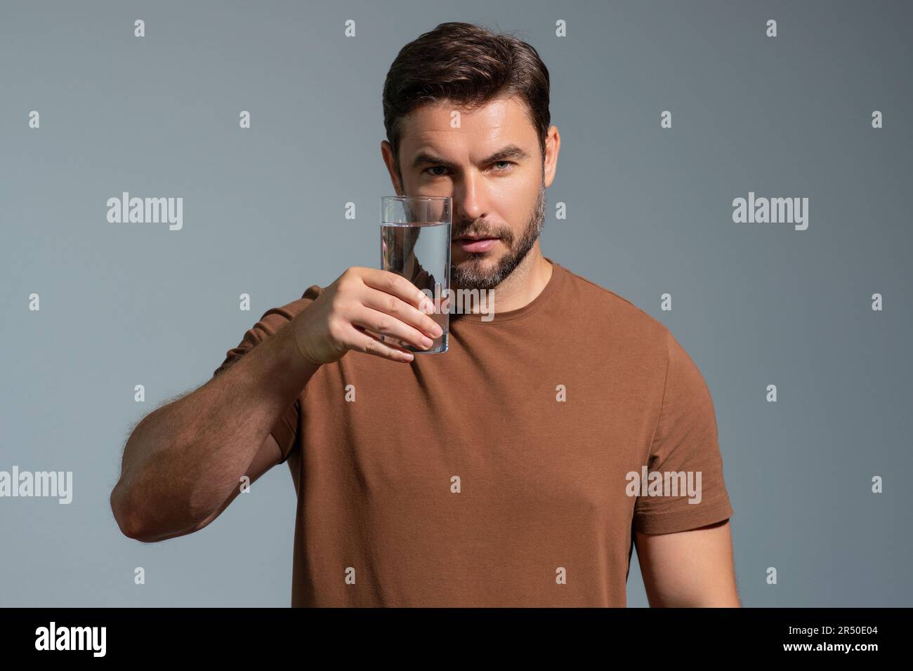Guy drinking water isolated on studio background. Man enjoy pure ...