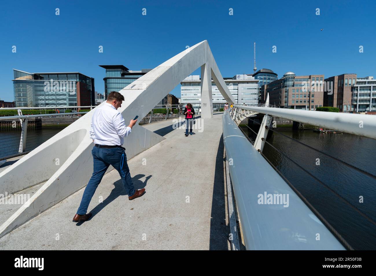 View of pedestrians crossing Tradeston Bridge or Squiggly bridge at ...