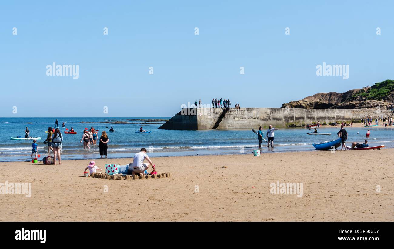 People enjoying the sunny weather at the coast. Cullercoats Bay, North ...