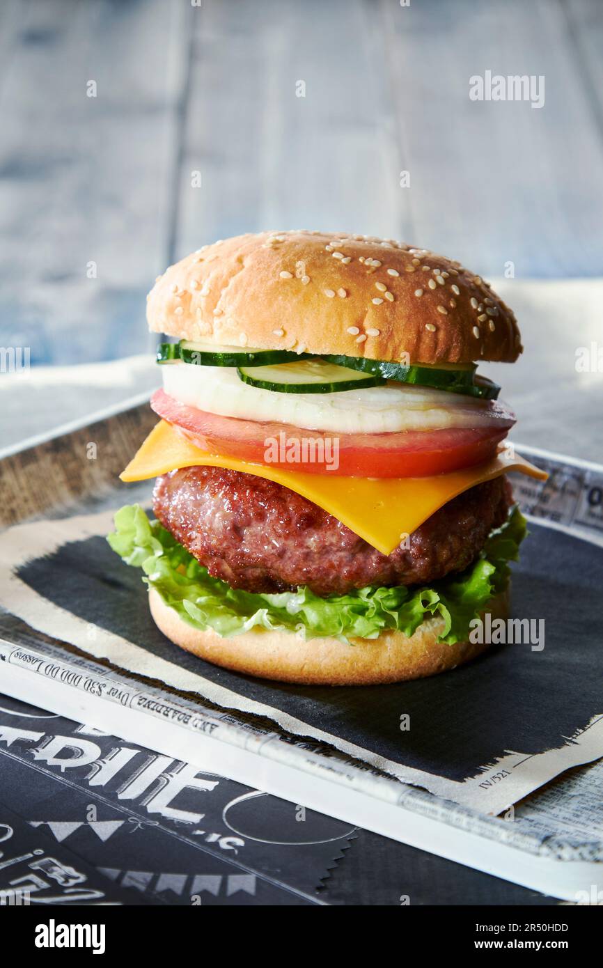 Burger with lettuce, cheese, tomato, onion, and pickles Stock Photo - Alamy