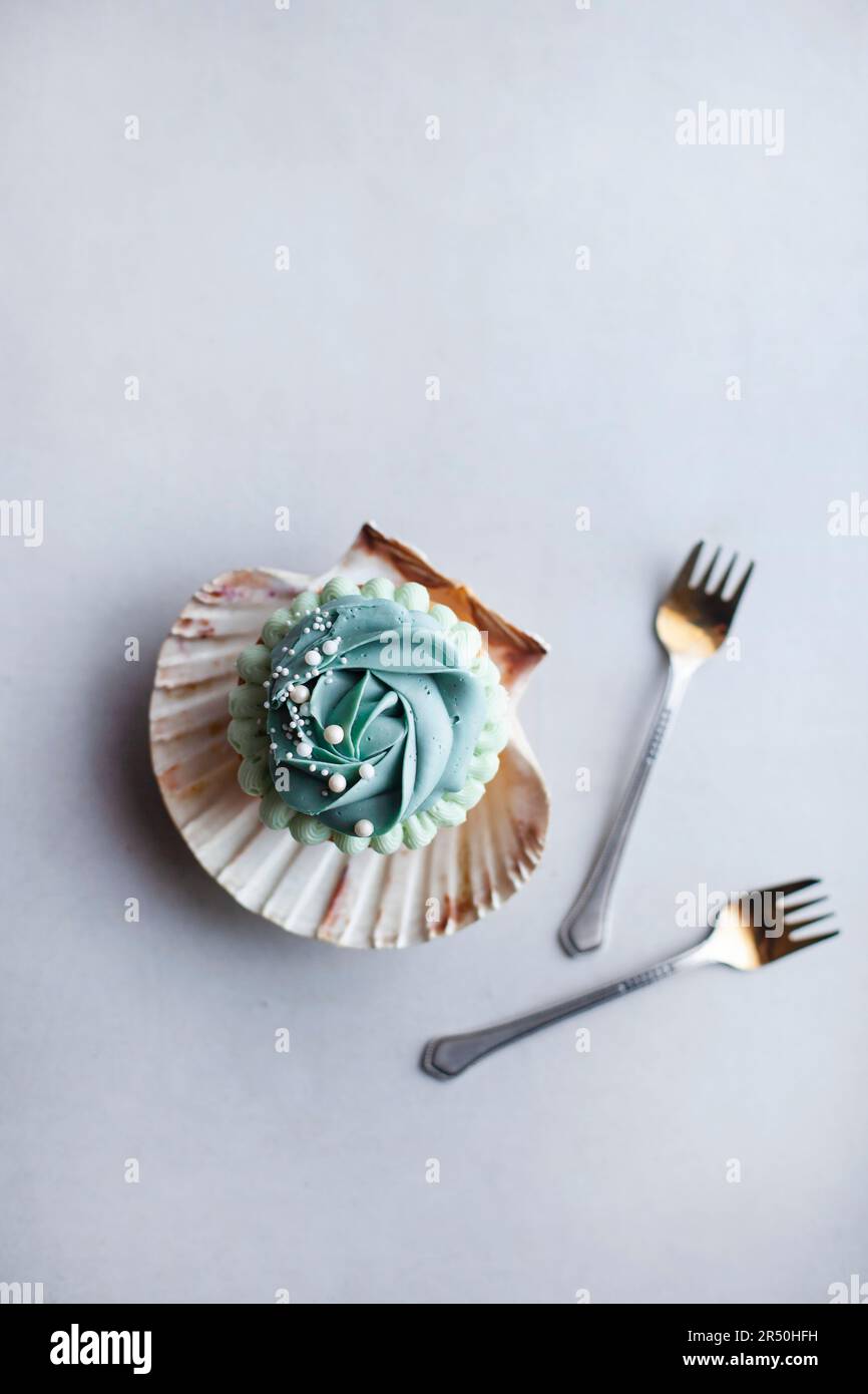 Monoportion cupcake with blue frosting in a clam shell Stock Photo - Alamy