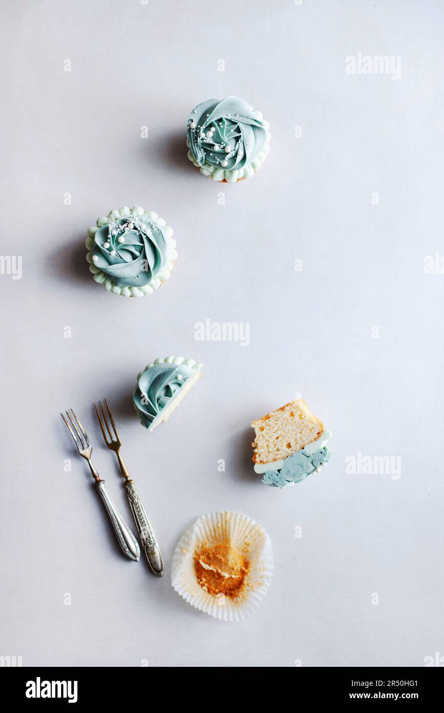 Whole and half cupcake with blue frosting Stock Photo - Alamy