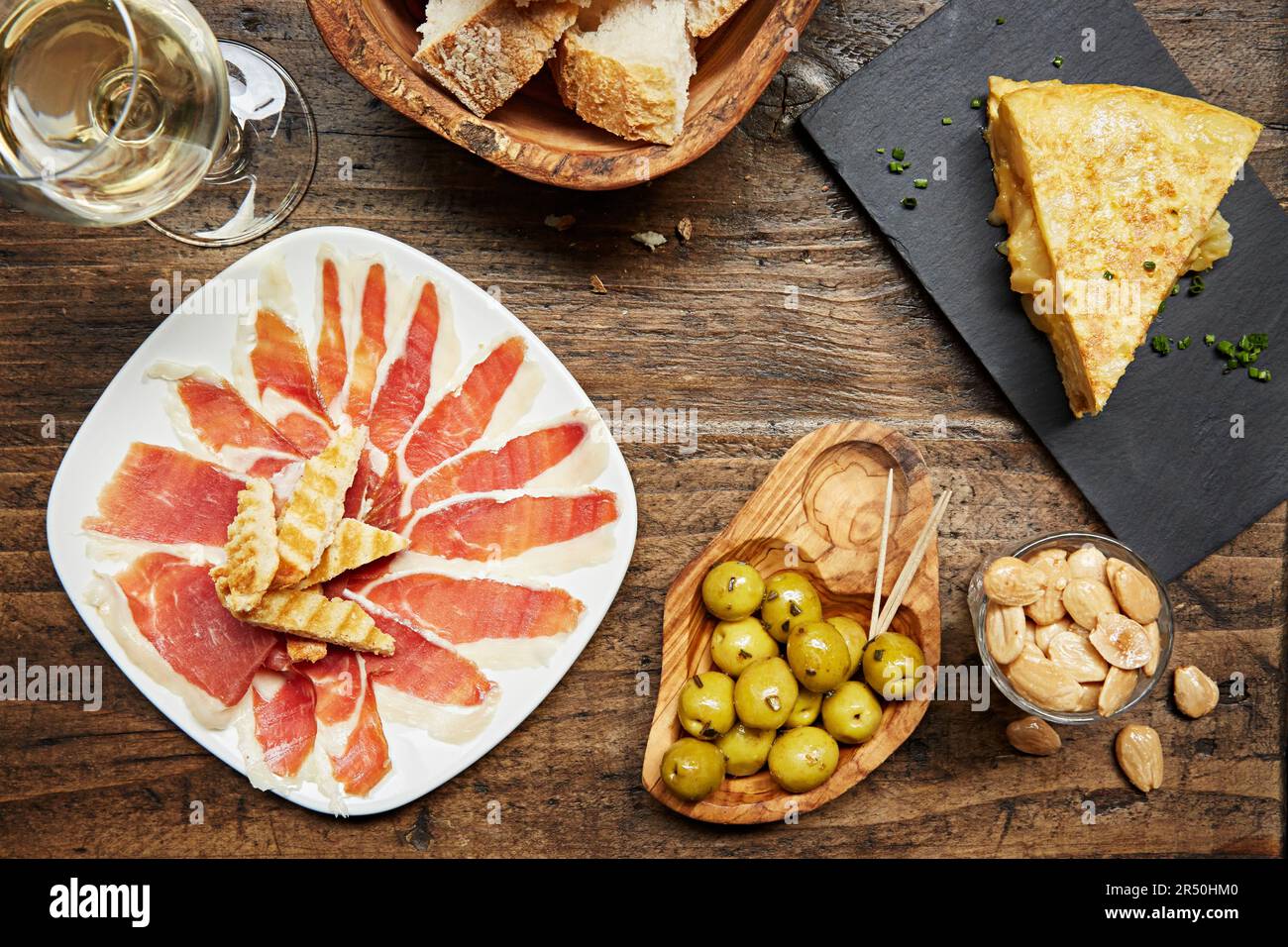 Spanish tapas Parma ham, olives and a tortilla spread on a table Stock ...