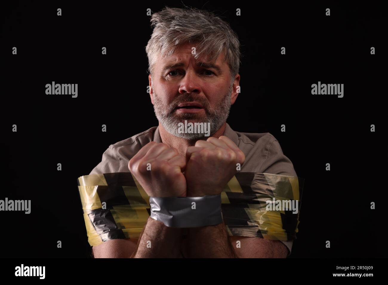 Victim tied with duct tape on black background. Hostage taking Stock ...