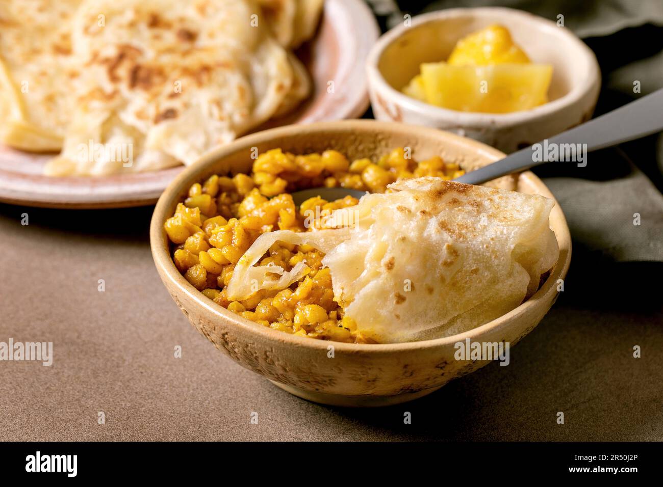Traditional indian yellow pea dal with roti flatbread and lemons Stock ...