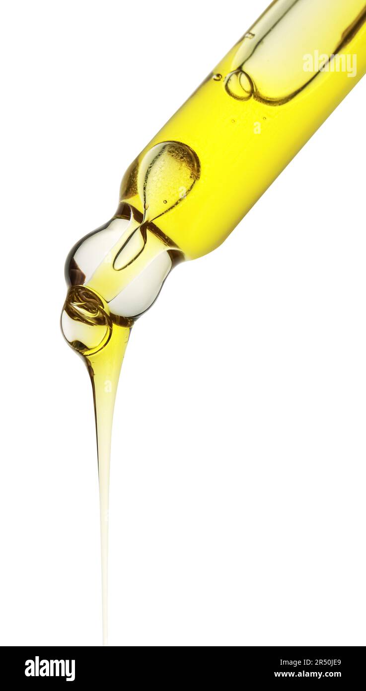 Dripping yellow facial serum from pipette on white background, closeup ...