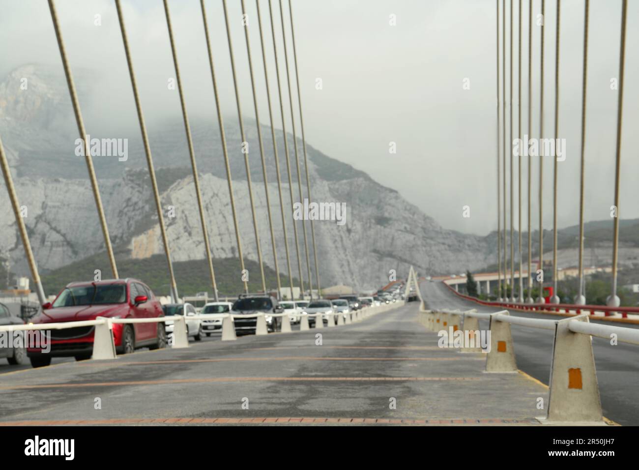View of cars on modern bridge near mountain Stock Photo - Alamy