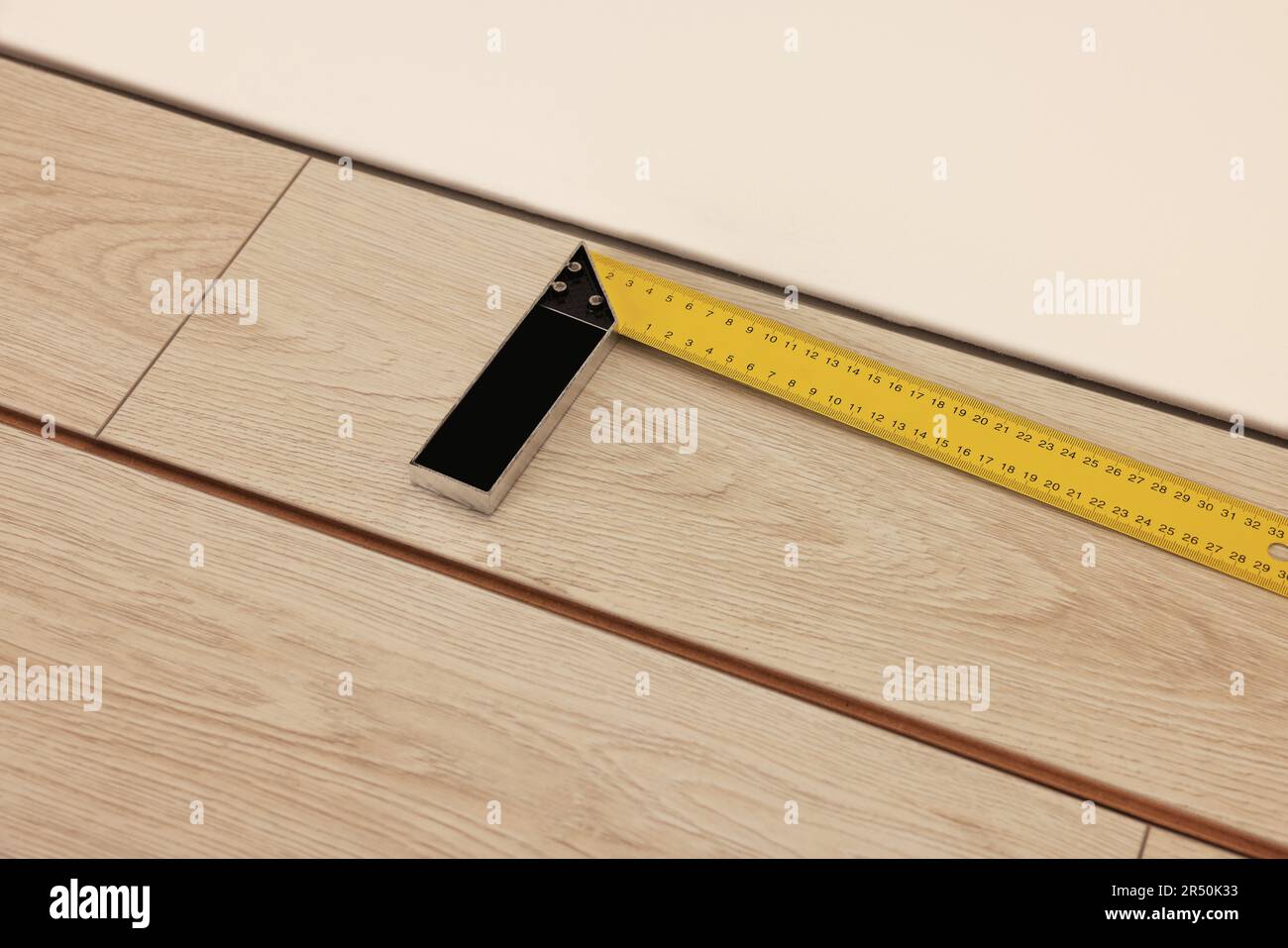 Ruler and parquet planks on floor in room Stock Photo - Alamy