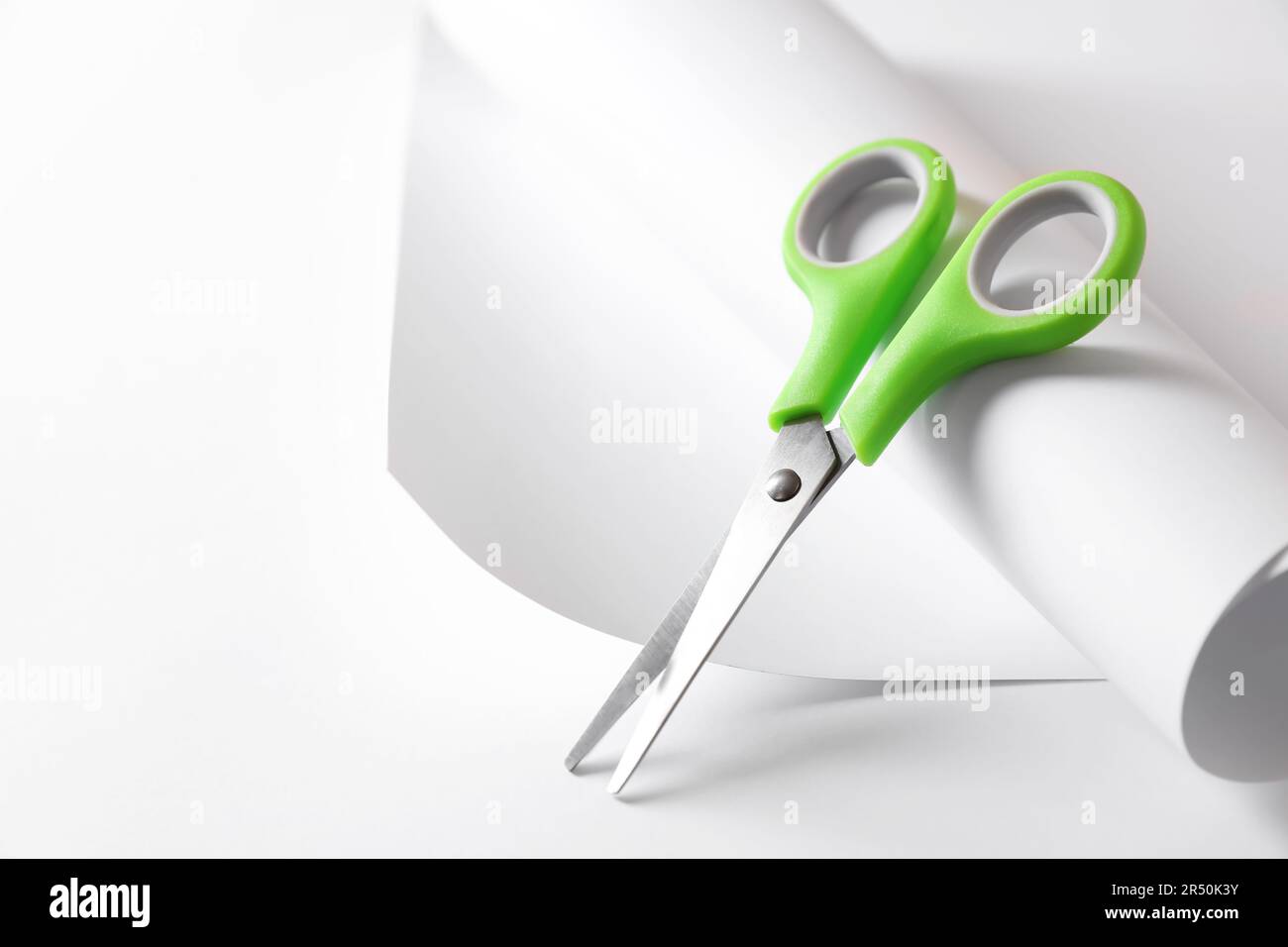 Green scissors and paper on white background Stock Photo - Alamy