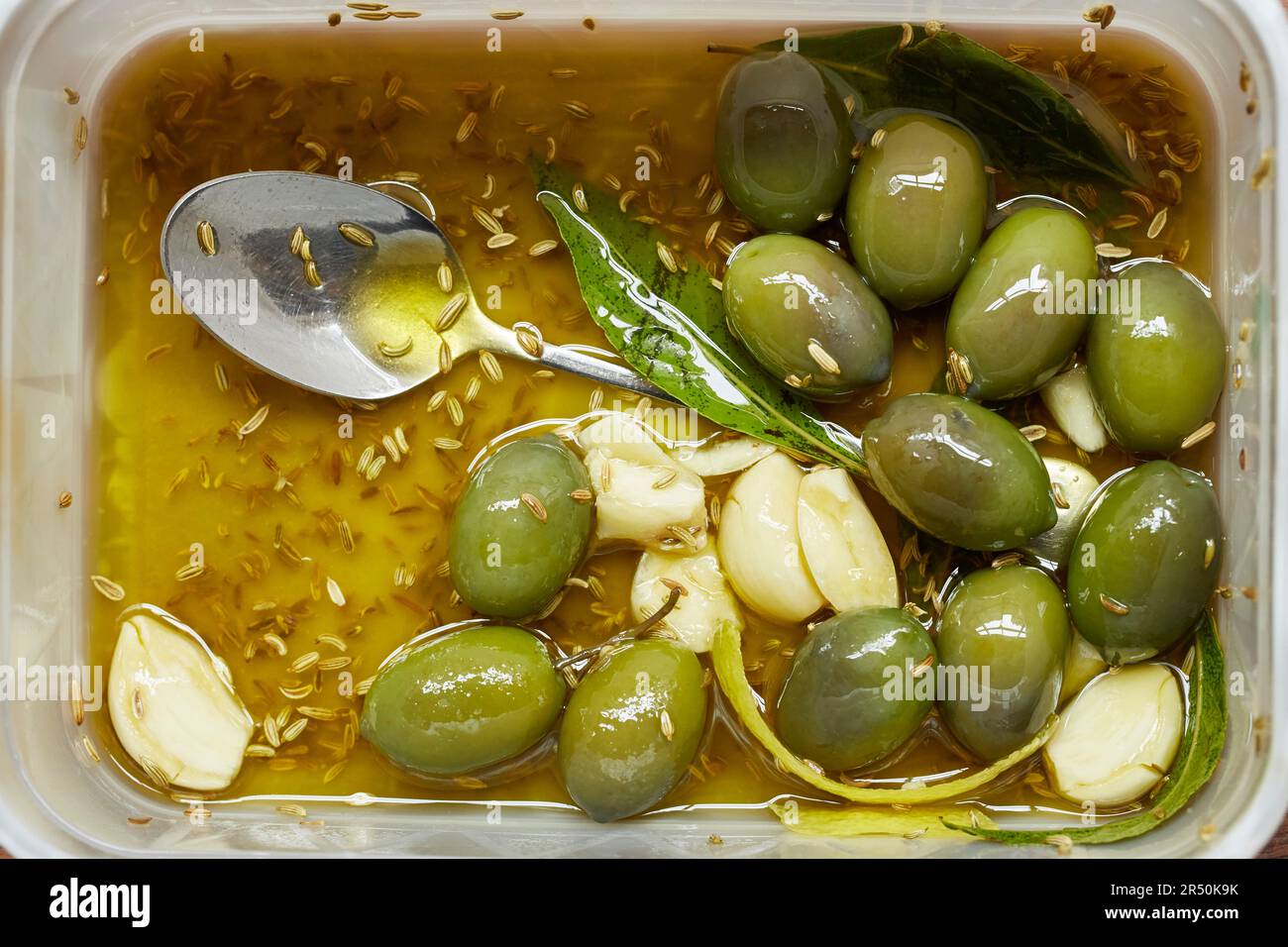 Green olives in oil with garlic and cumin seeds Stock Photo - Alamy