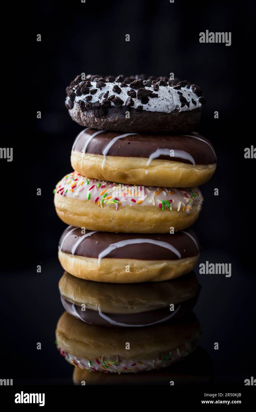 A stack of doughnuts against a black background Stock Photo - Alamy