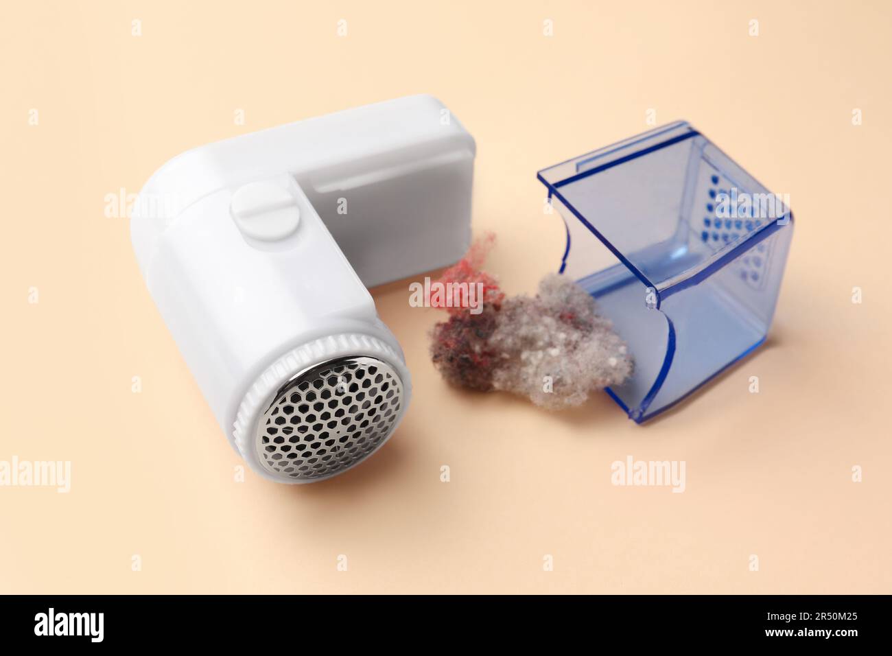 Fabric shaver with fuzz on beige background, closeup. Modern appliance ...