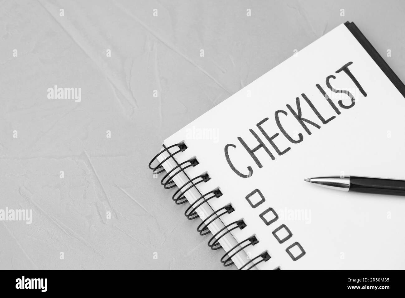 Notebook with inscription Checklist on light grey table, top view ...