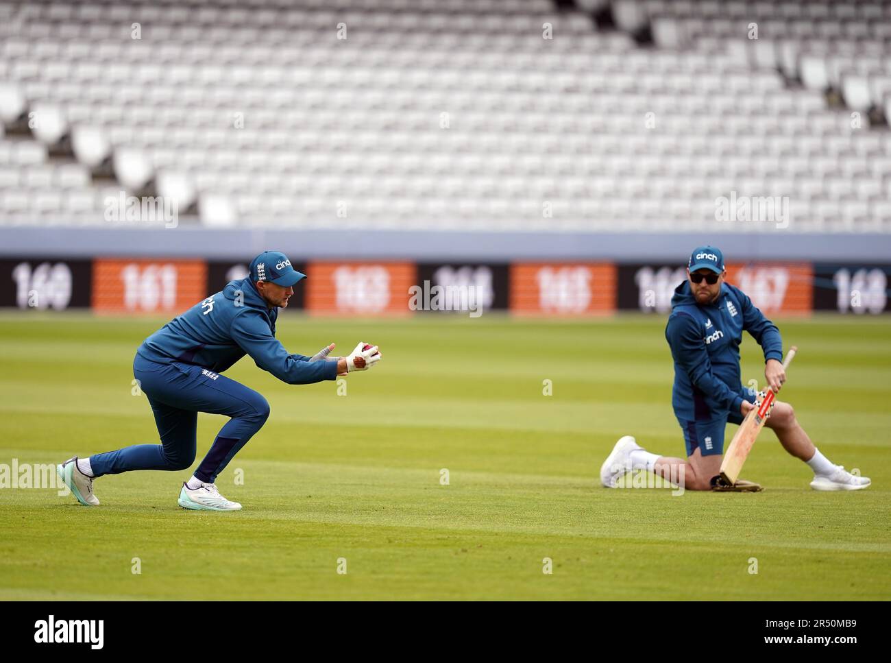 England head coach Brendon McCullum helps Joe Root practice his slip ...