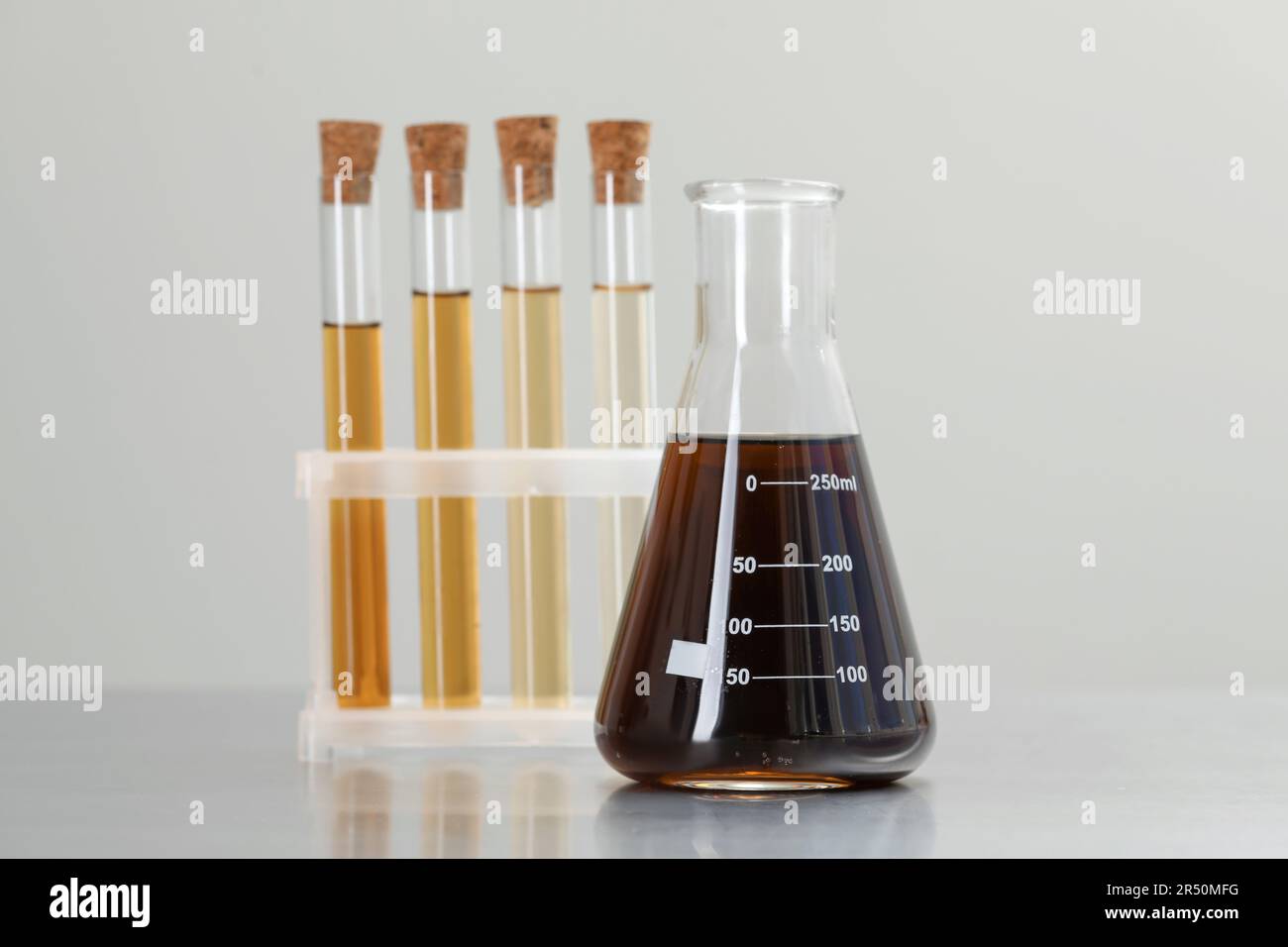 Laboratory glassware with brown liquids on light background Stock Photo ...