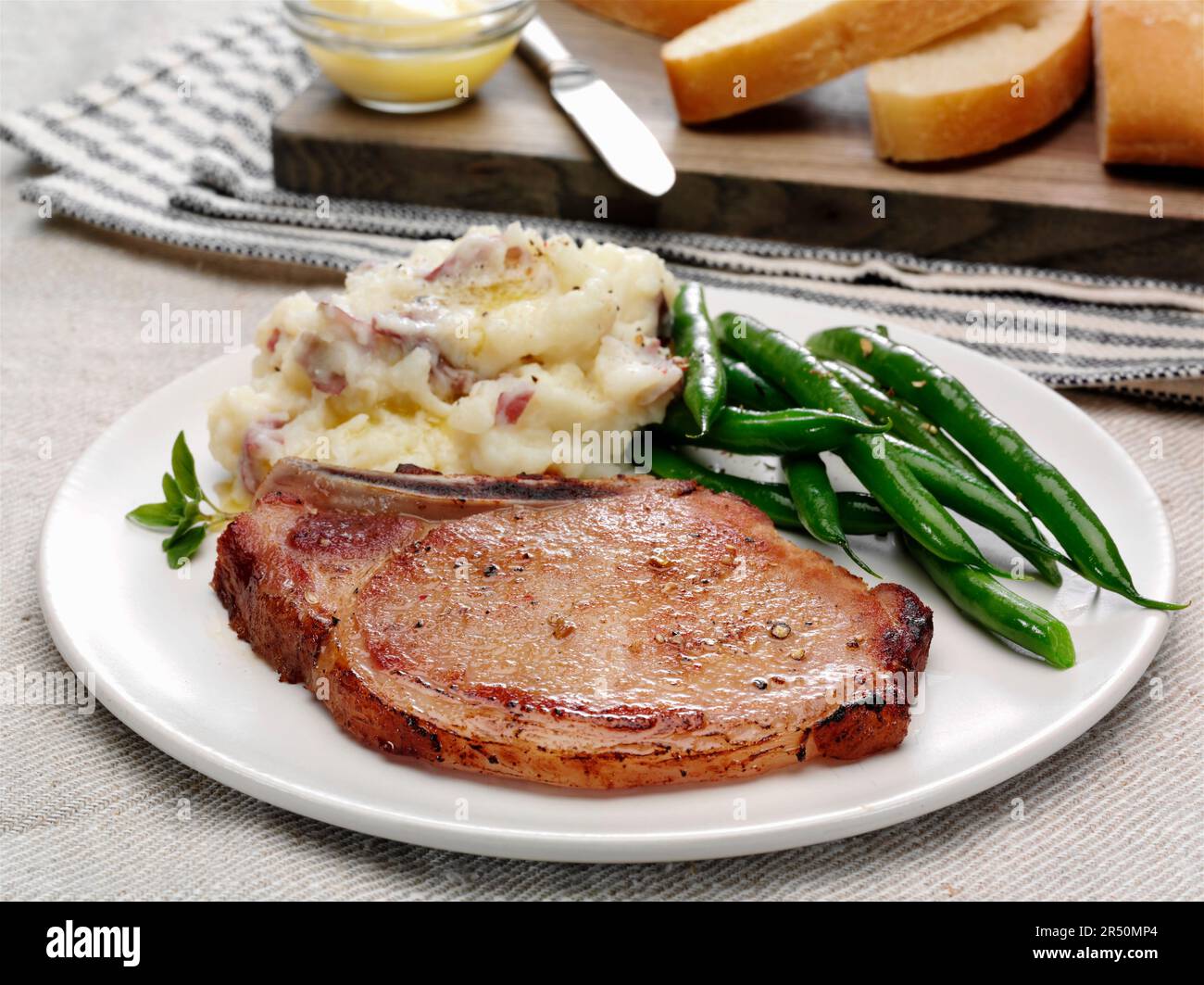 A bone in pork chop with green beans and mashed potatoes Stock Photo ...