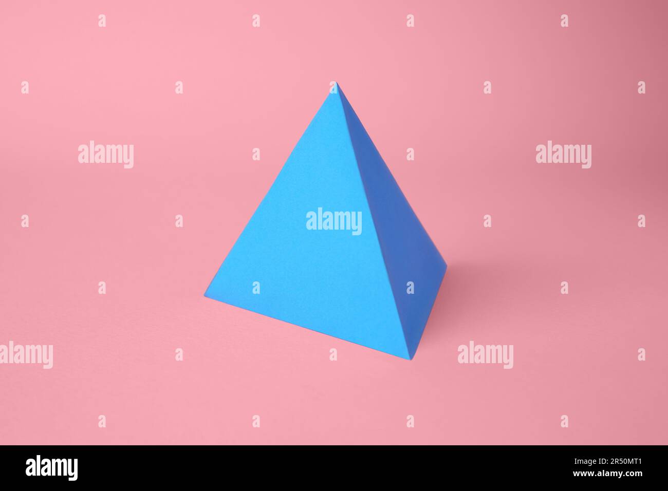 Origami art. Paper pyramid on pink background Stock Photo - Alamy