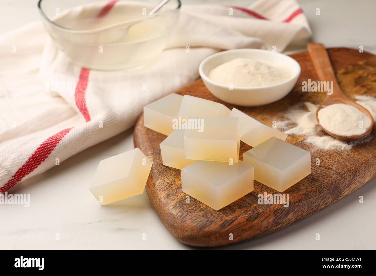 Agar-agar jelly cubes and powder on white marble table, closeup Stock ...