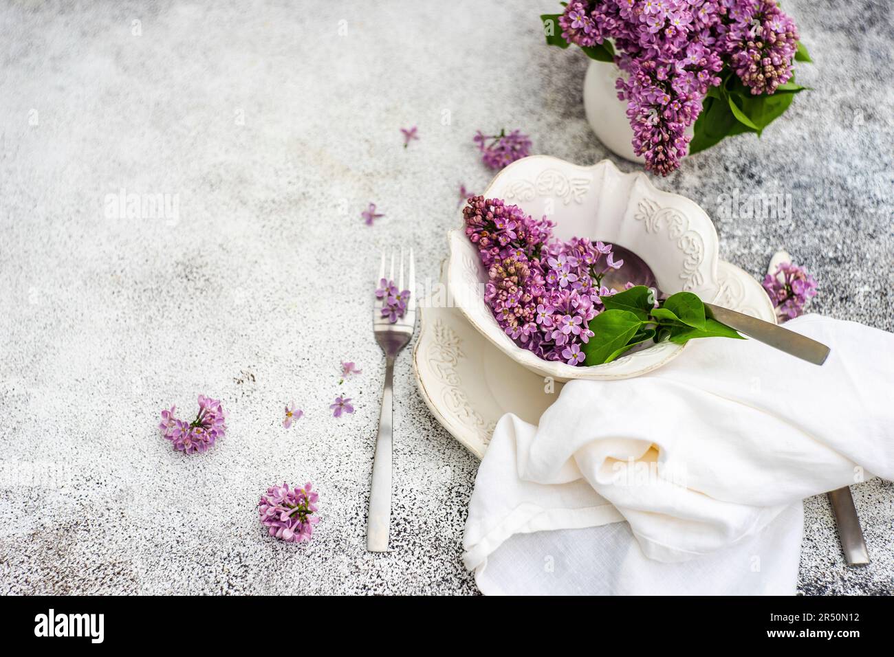 Spring place setting with lilac flowers on outdoor table Stock Photo ...
