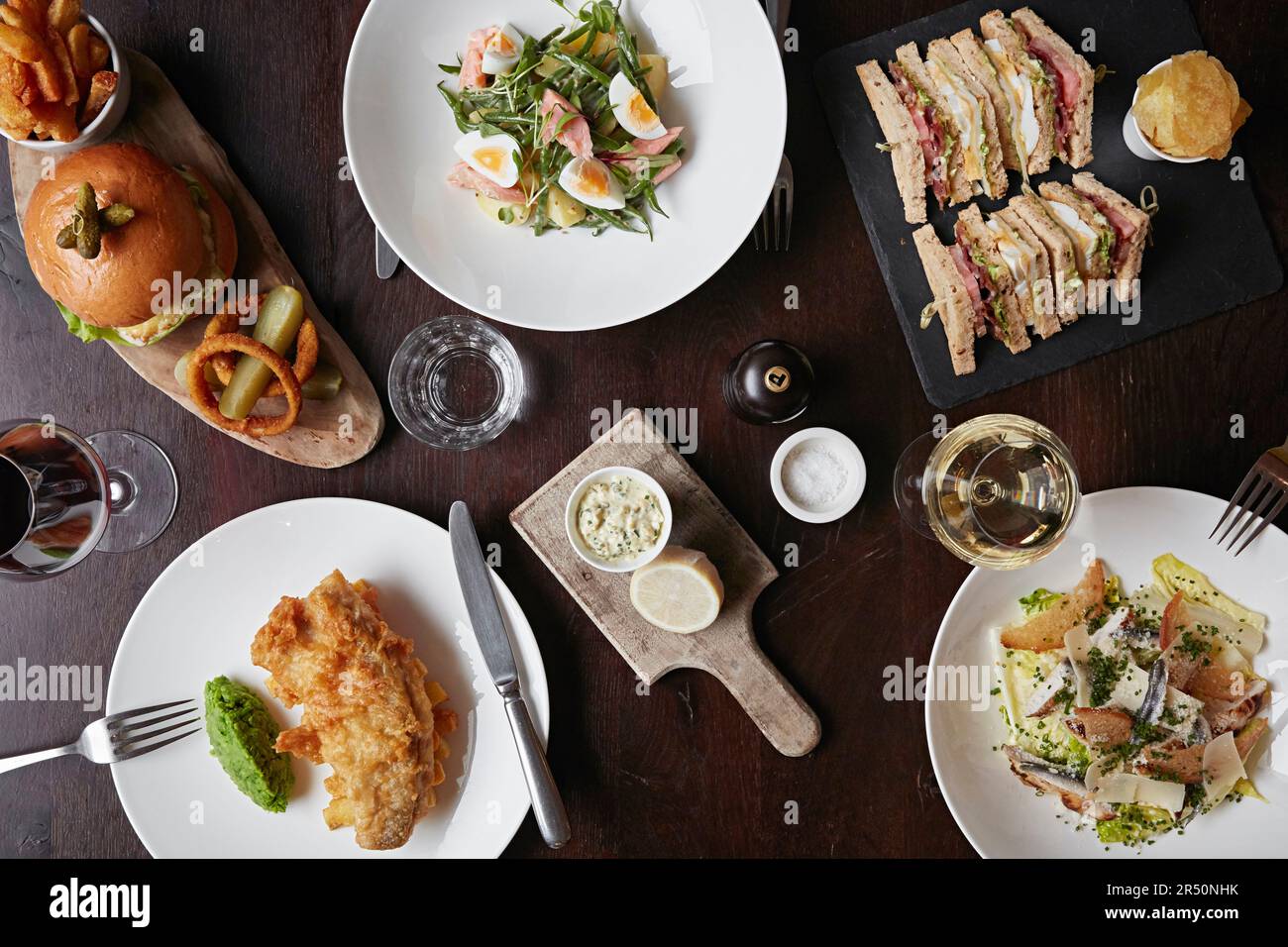 Selection of lunch dishes laid out on a table with wine and cutlery ...