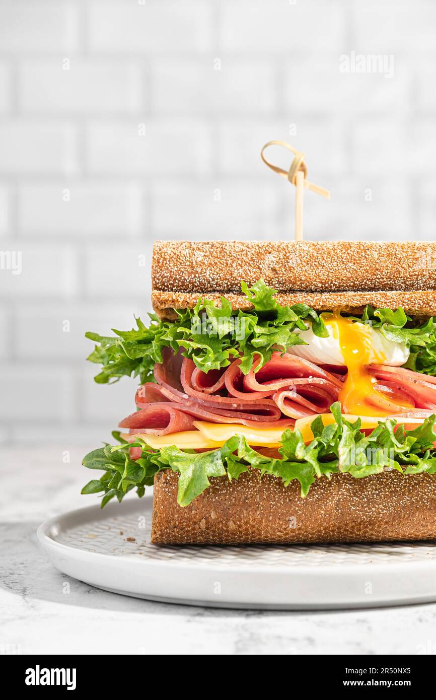 Sandwith with ham, cheese, lettuce, and poached egg Stock Photo - Alamy