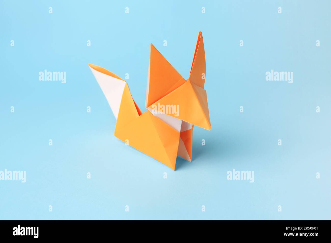 Origami art. Handmade orange paper fox on light blue background Stock ...