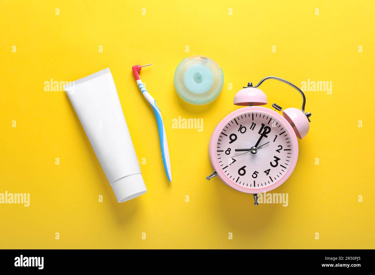 Container with dental floss, toothpaste and toothbrush on yellow ...