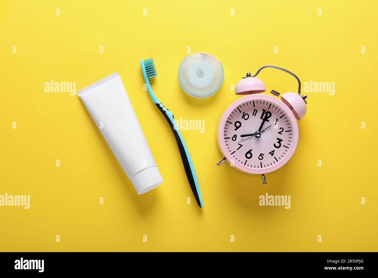 Container with dental floss, toothpaste and toothbrush on yellow ...