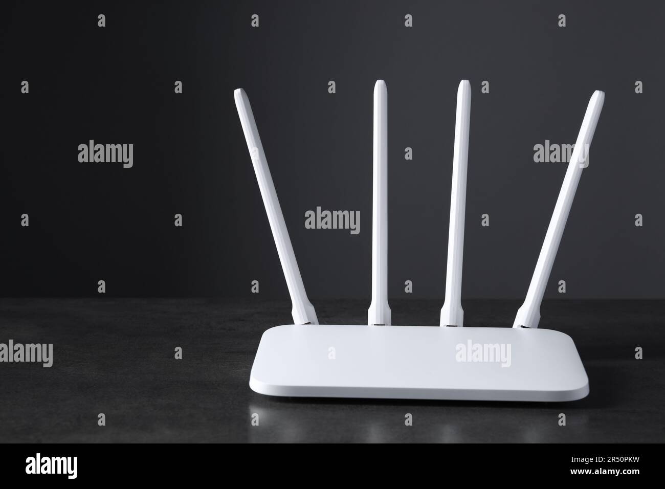 New stylish Wi-Fi router on black textured table. Space for text Stock ...