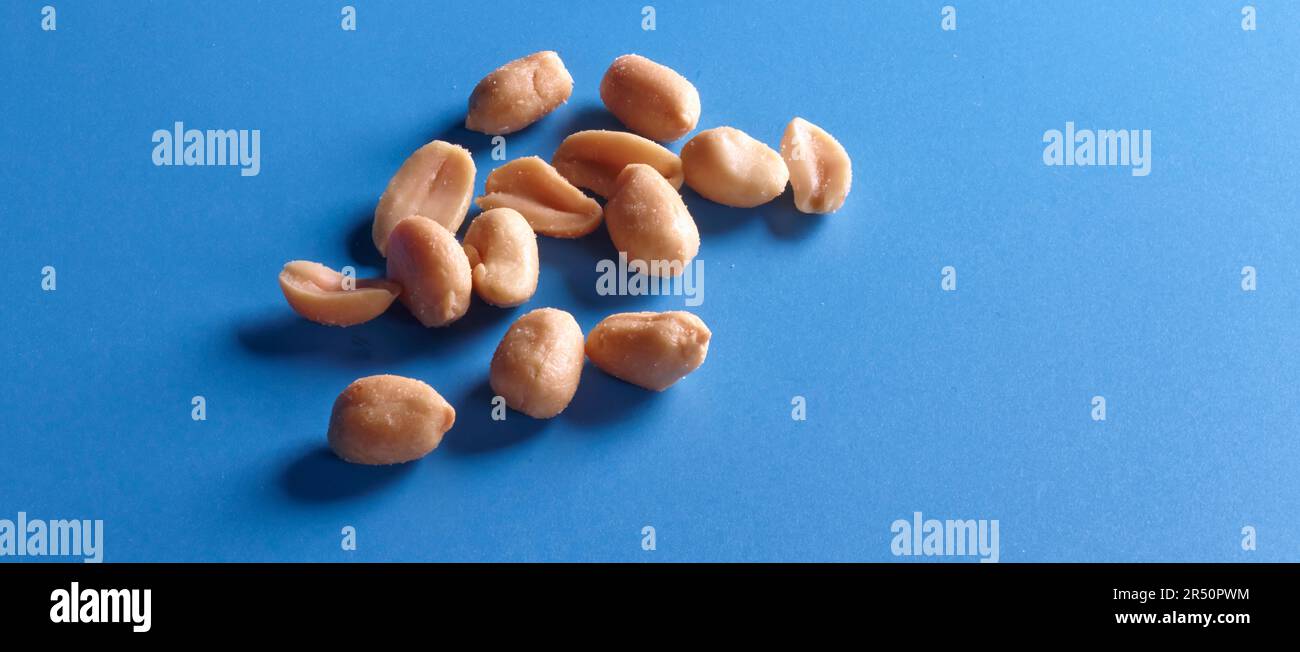 Peanuts on a blue background Stock Photo - Alamy