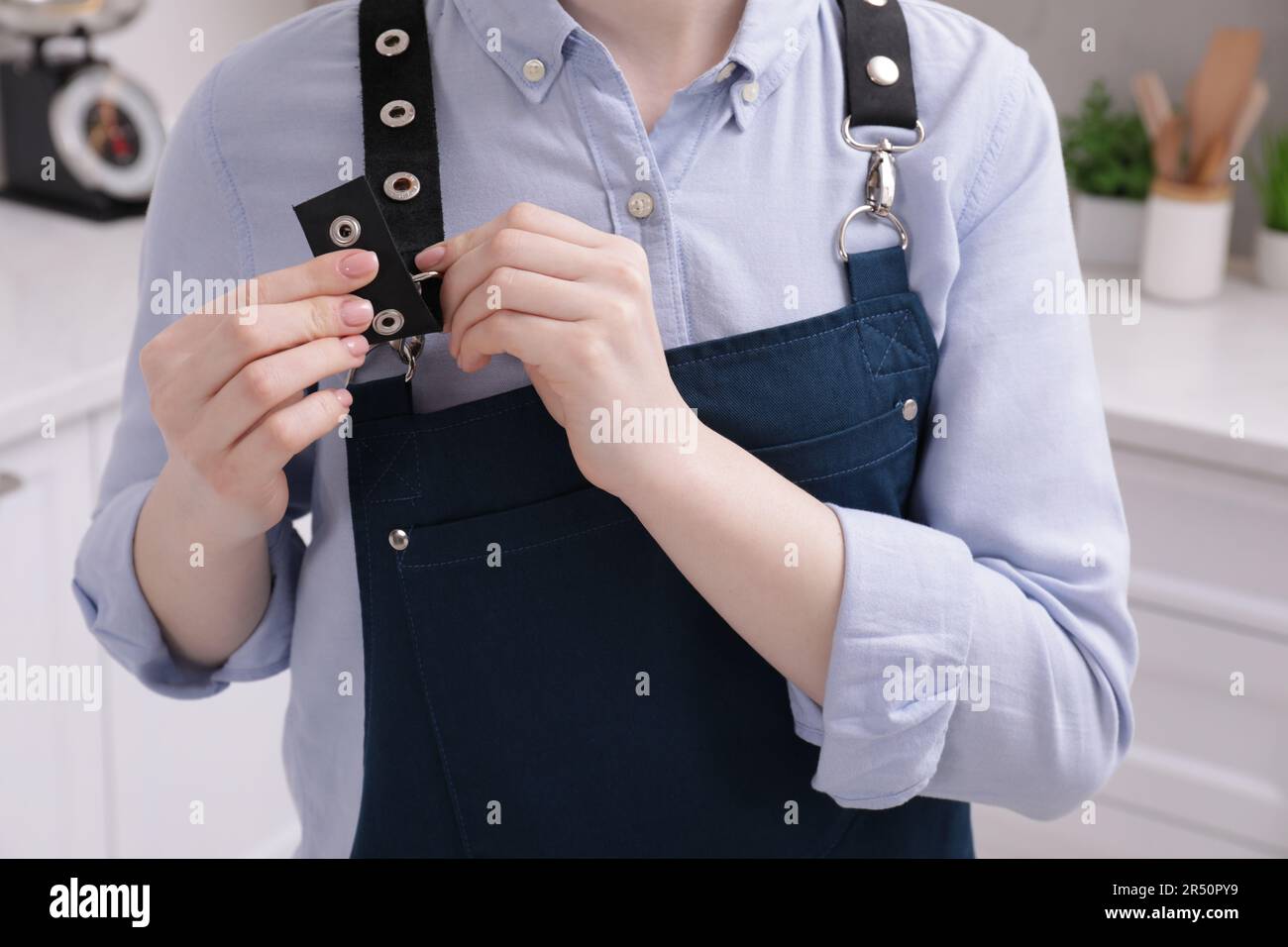 Woman putting on apron in hi-res stock photography and images - Alamy