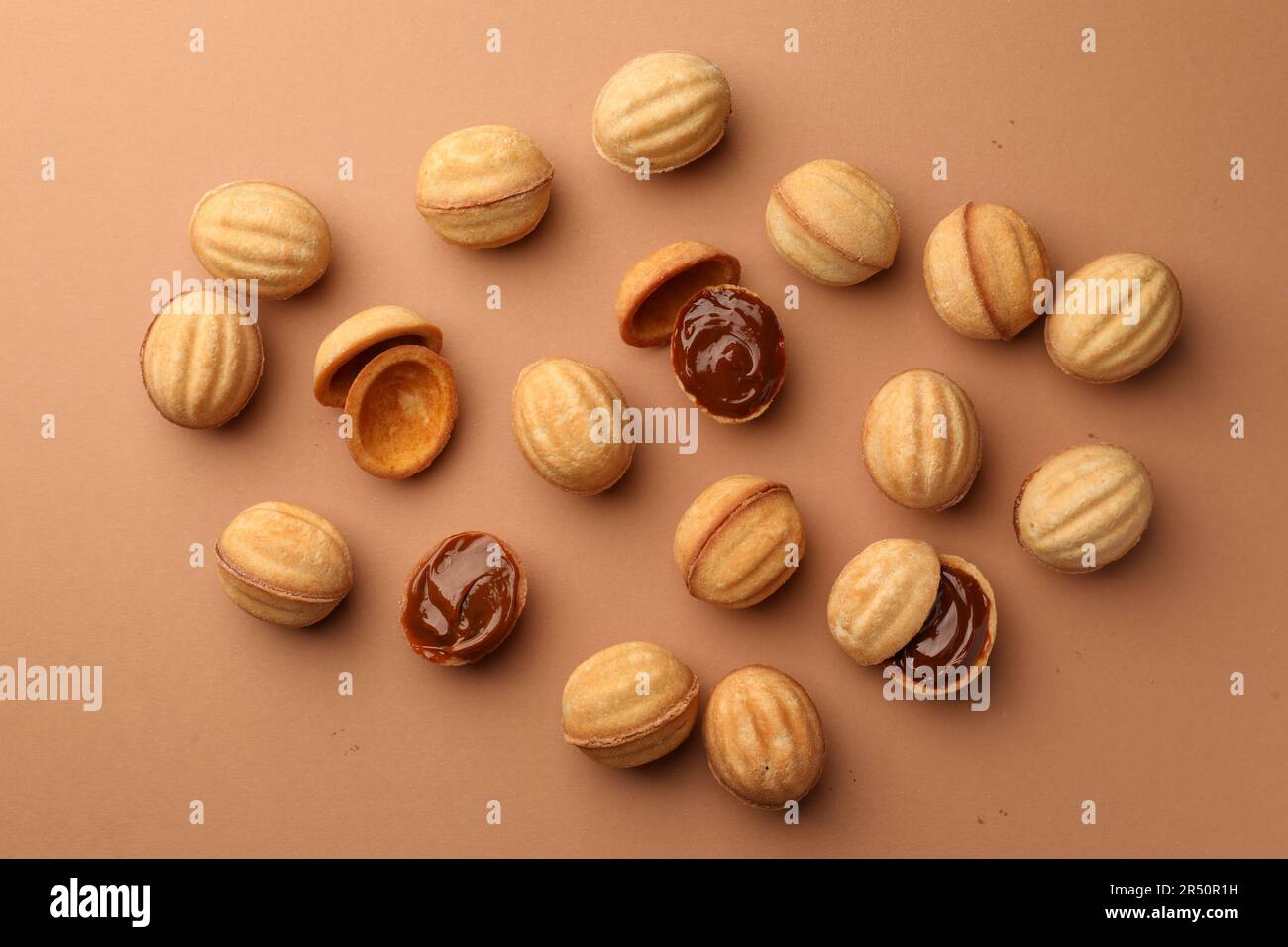 Homemade walnut shaped cookies with boiled condensed milk on pale brown ...