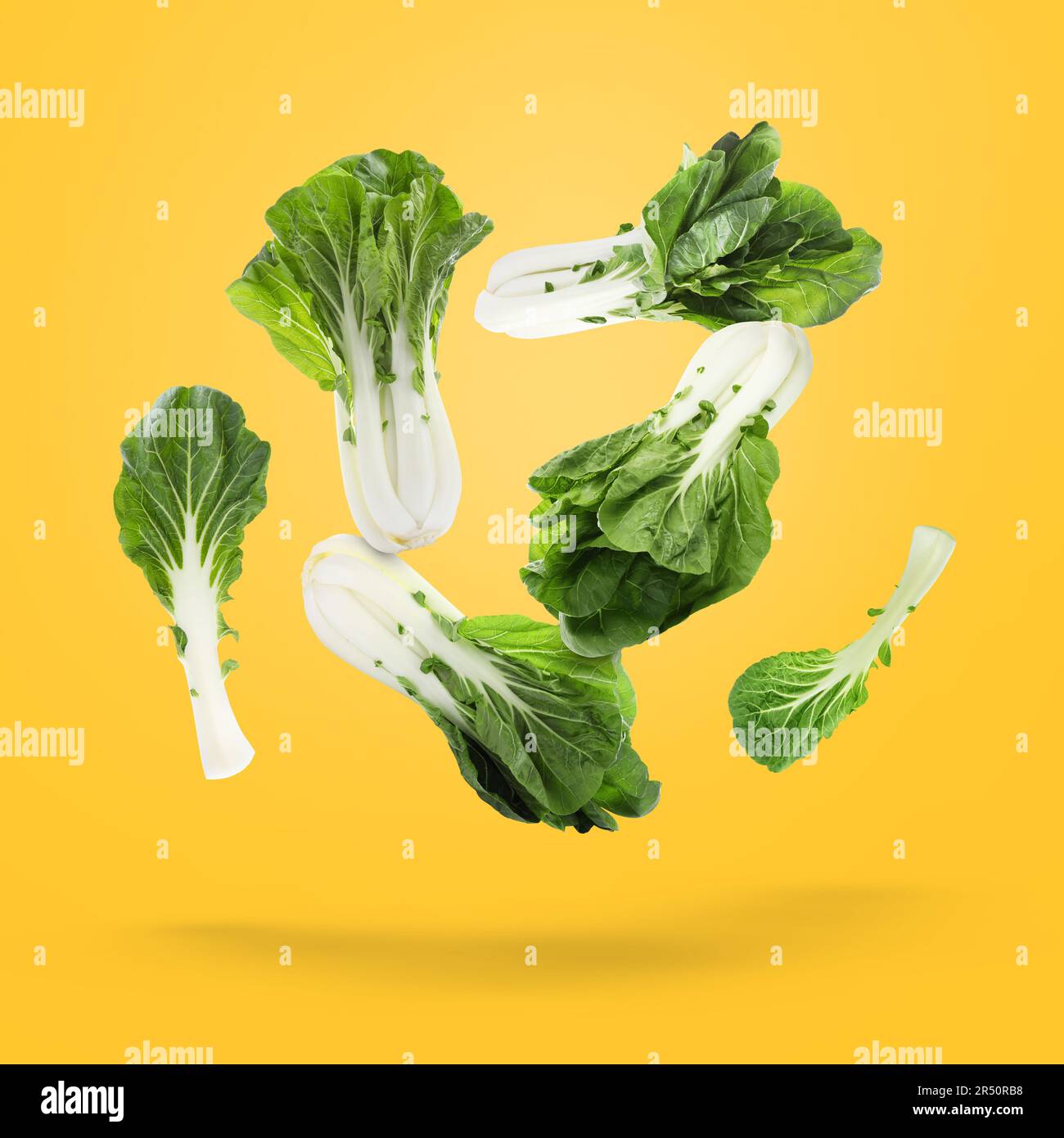 Fresh green pak choy cabbages falling on yellow background Stock Photo ...